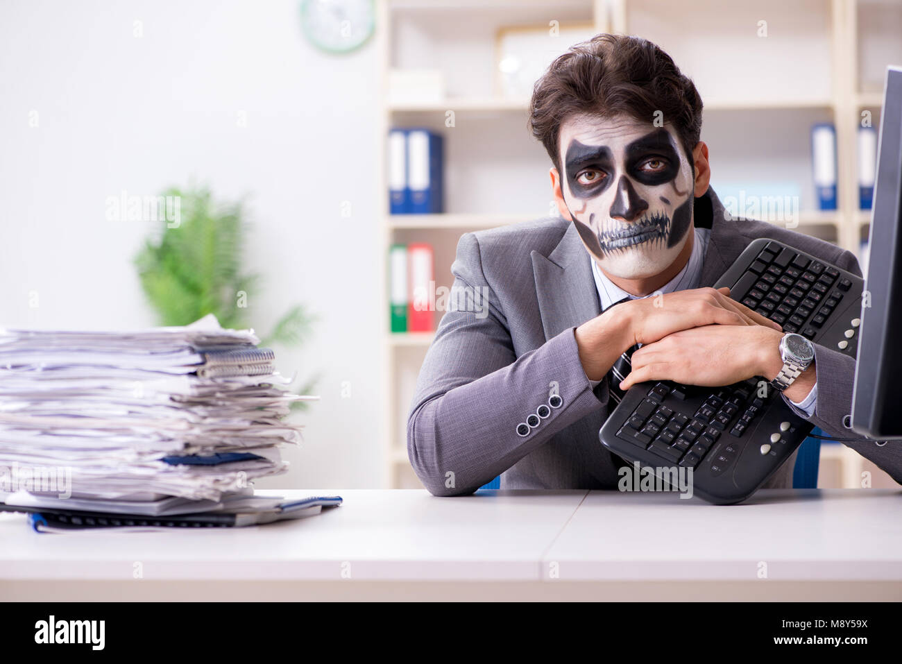 Businessman with scary face mask working in office Stock Photo - Alamy