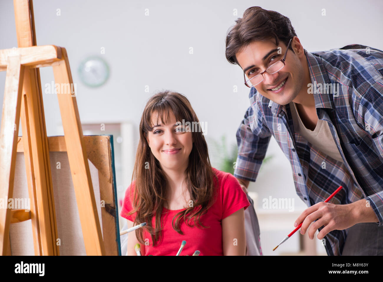 Artist coaching student in painting class in studio Stock Photo - Alamy