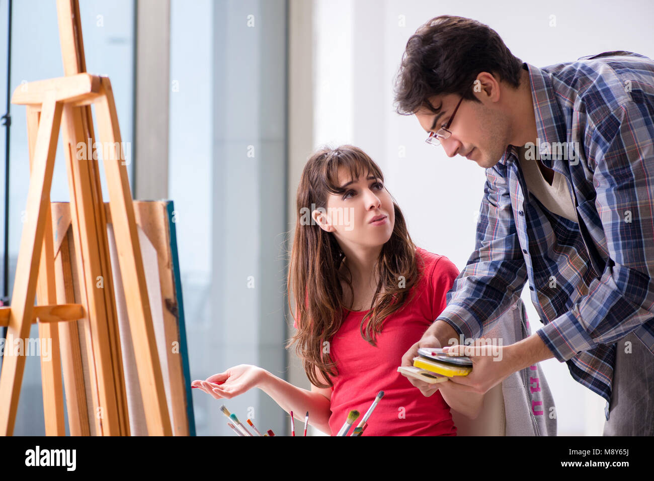 Artist coaching student in painting class in studio Stock Photo - Alamy