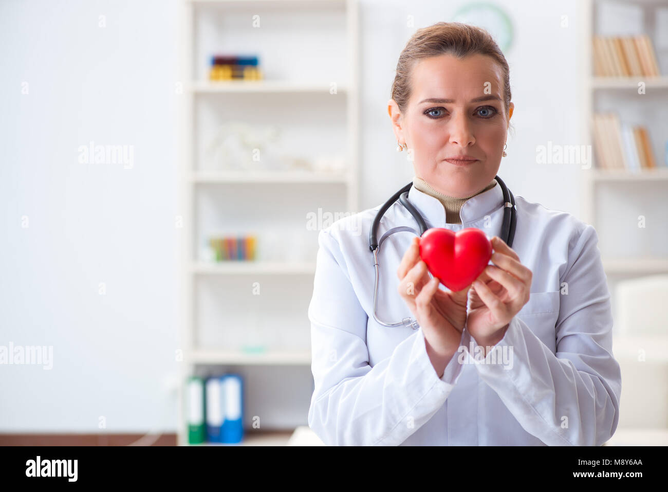 Cardiologist with red heart in medical concept Stock Photo - Alamy