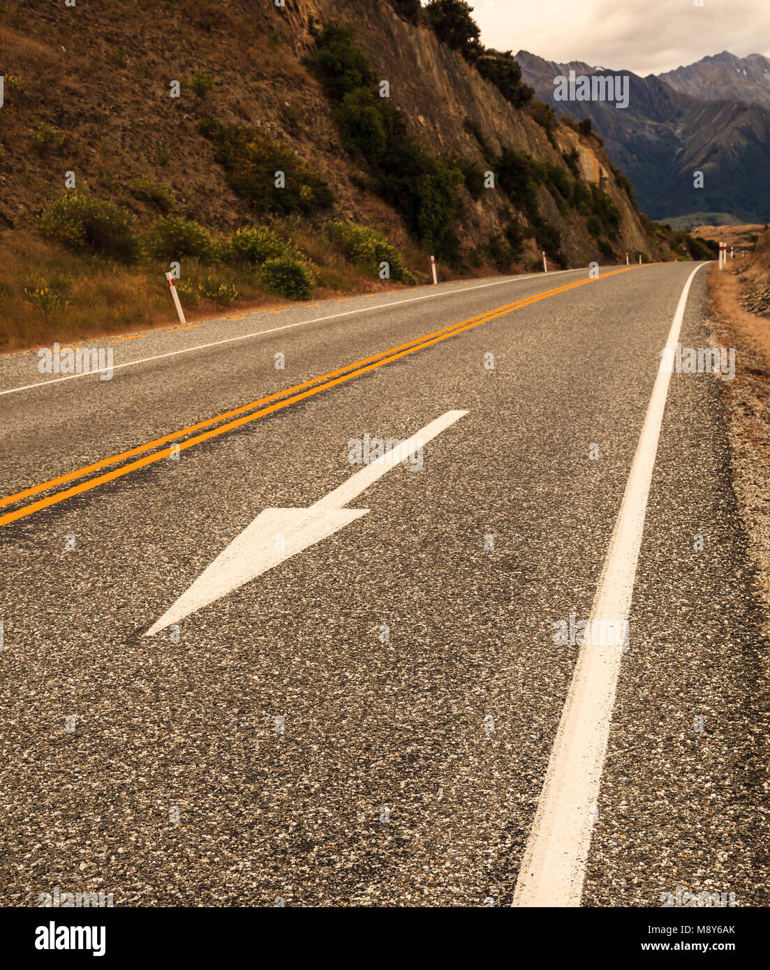 white arrow traffic sign, yellow dividing lines and white footpath line ...