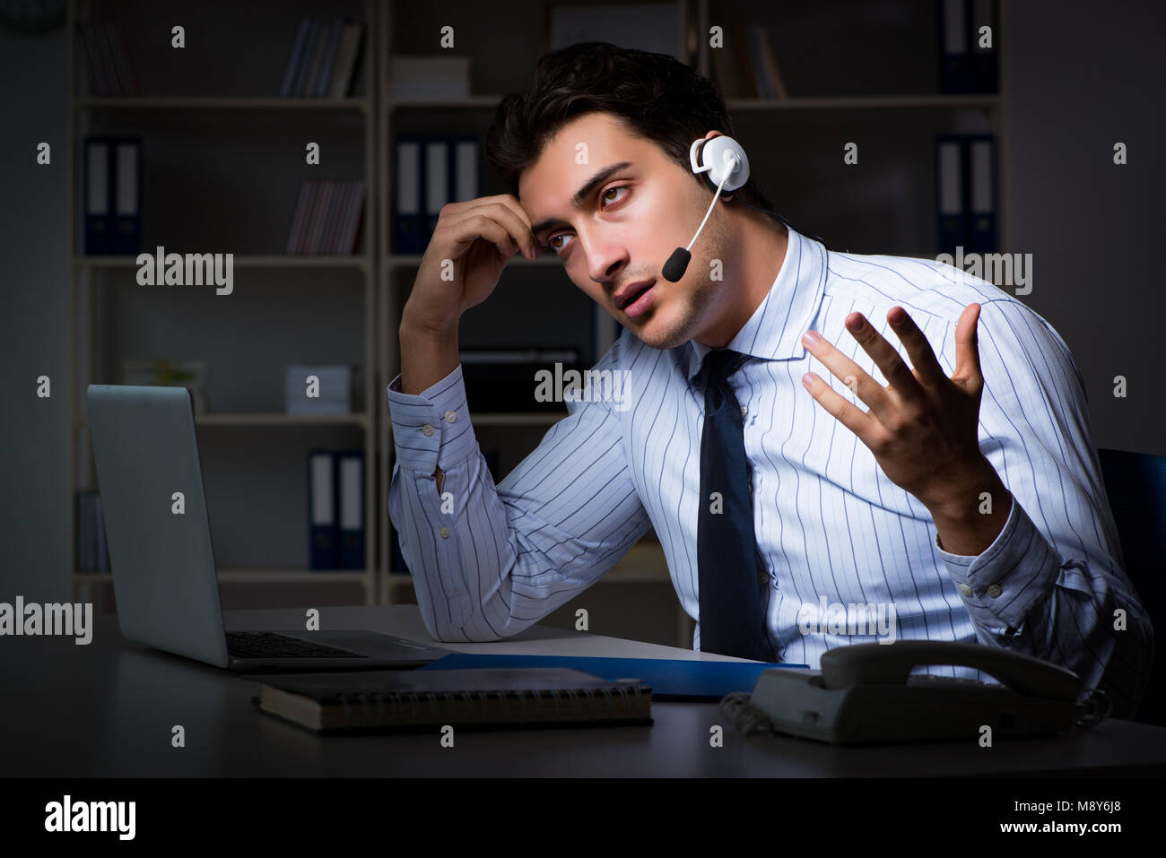 Tired and exhausted helpdesk operator during night shift Stock Photo ...