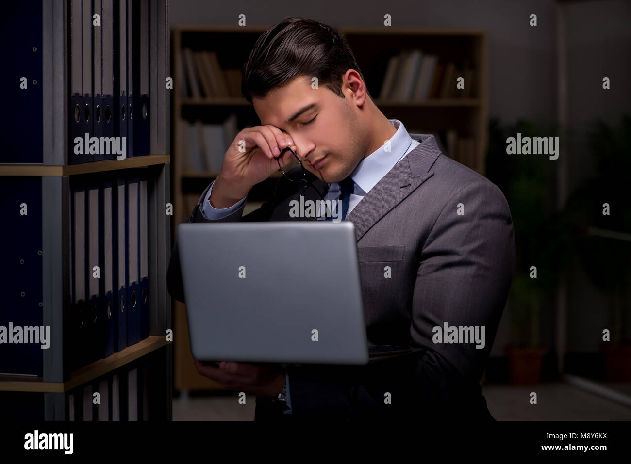 Businessman almost falling asleep working late hours in the office ...