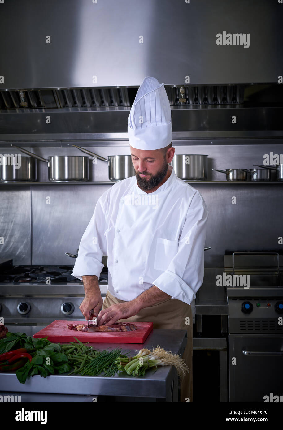 Chef cutting meat in restaurant kitchen of stainless steel Stock Photo ...