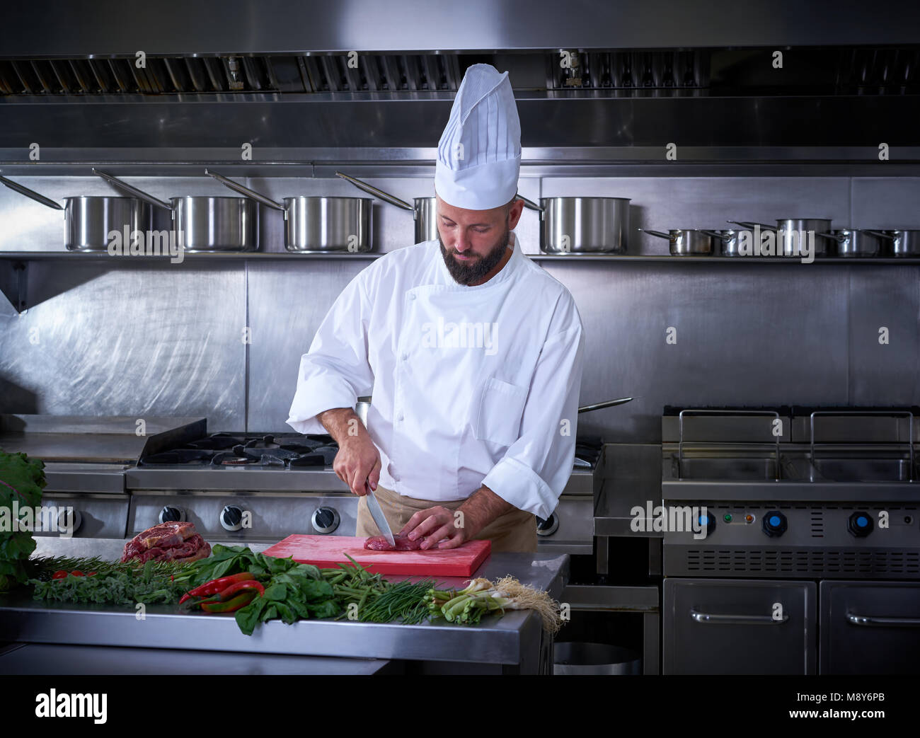 Chef cutting meat in restaurant kitchen of stainless steel Stock Photo ...