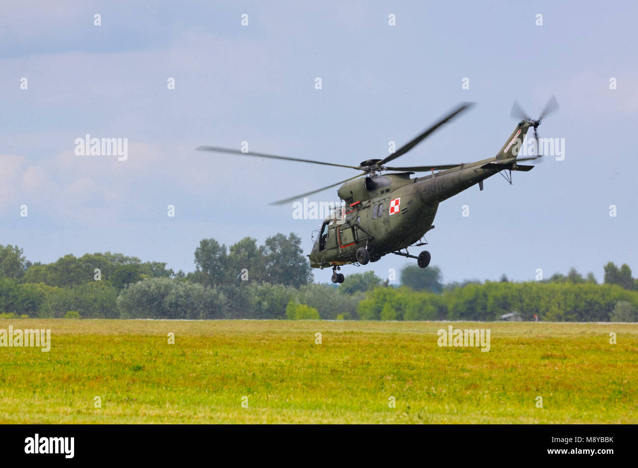 The Polish Air Force PZL W-3 Sokol (Falcon) flying over meadow during ...