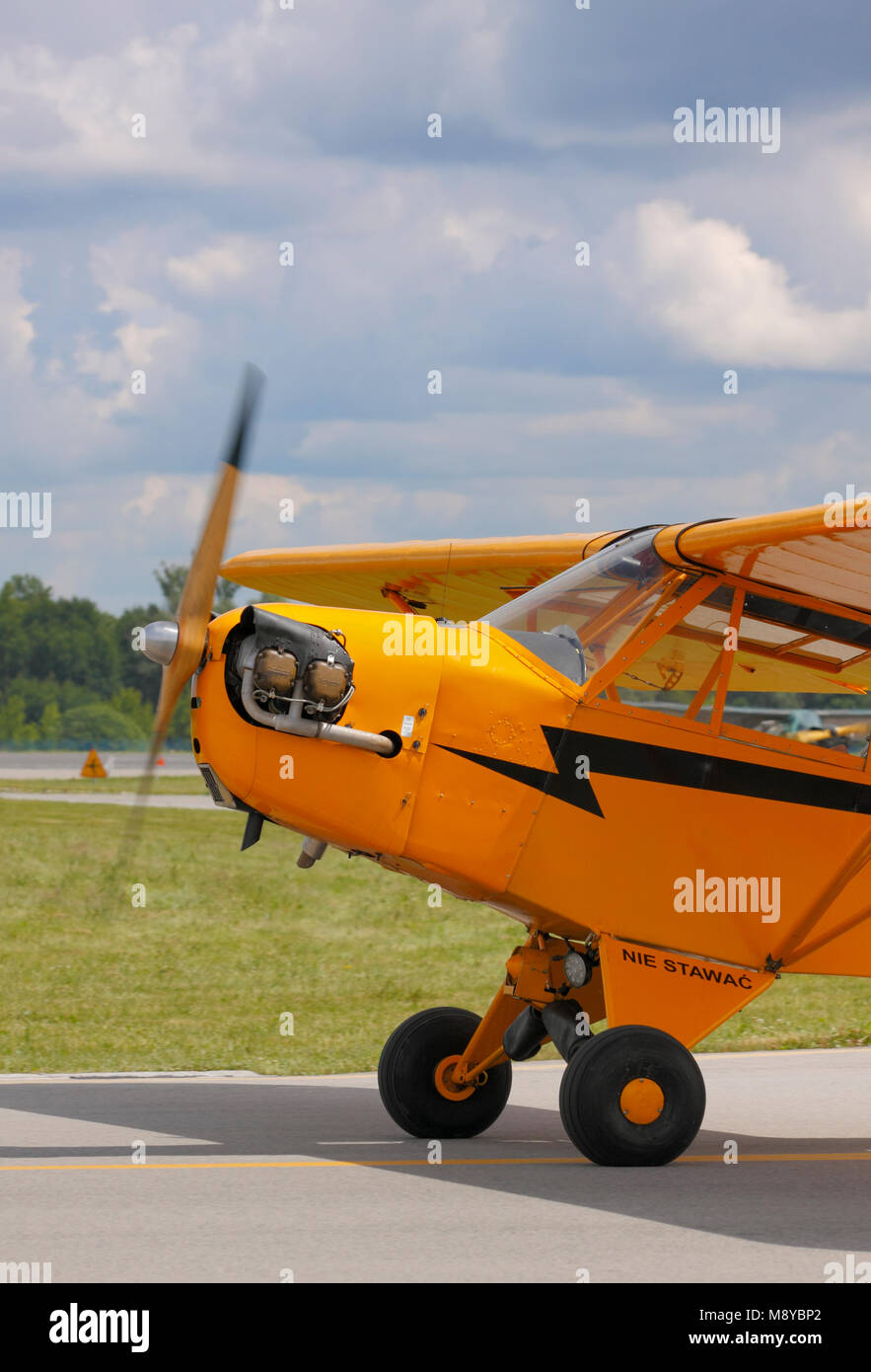 The Piper J-3 Cub ("Cub Yellow" hue) on runway during International Air ...