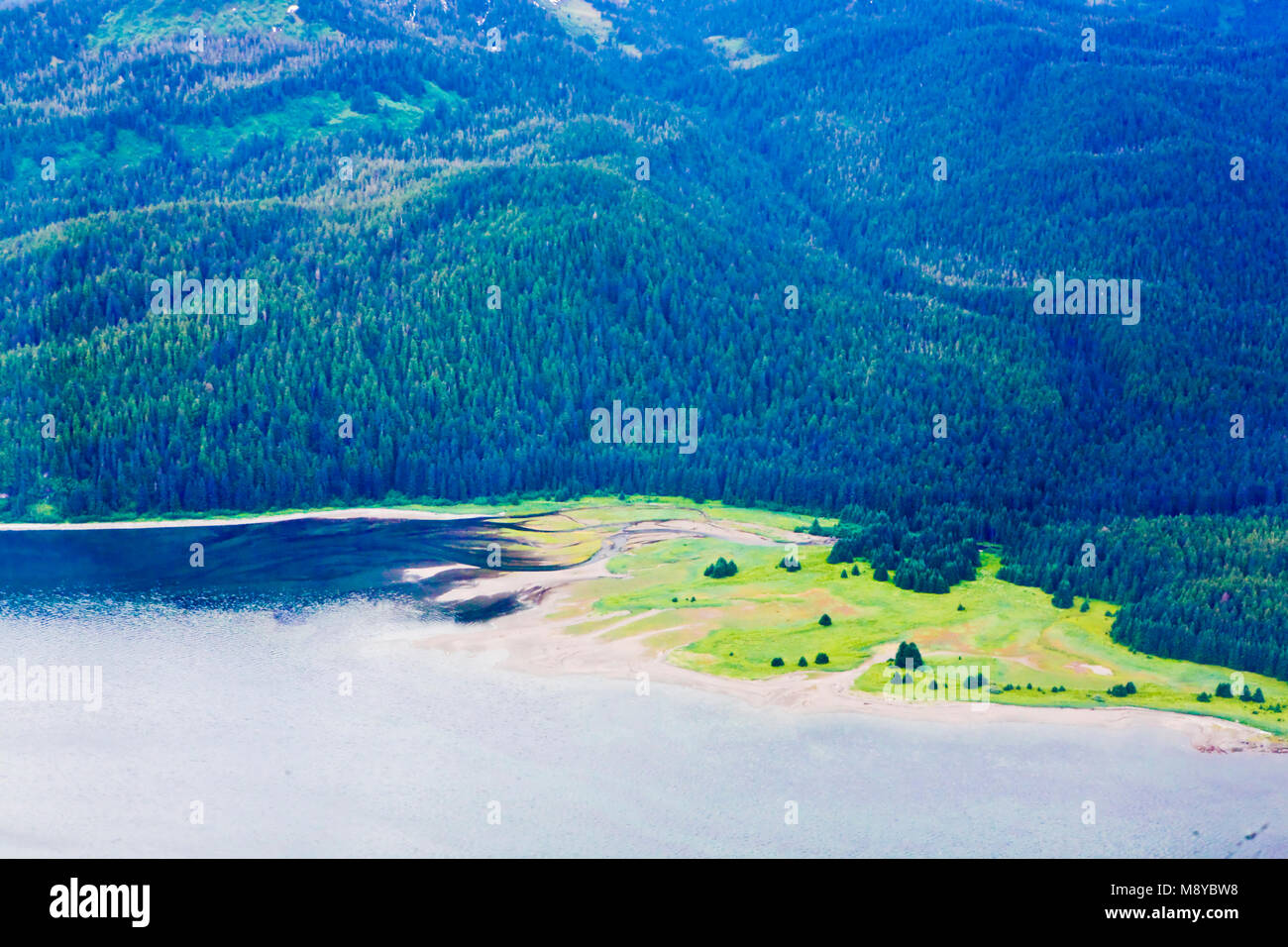 Aerial view of uninhabited areas of Alaska's forested coastline and ...