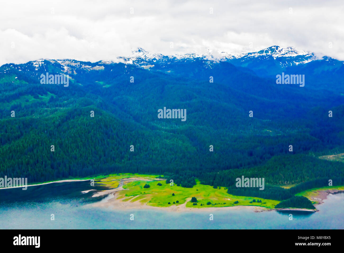 Aerial view of uninhabited areas of Alaska's forested coastline and ...