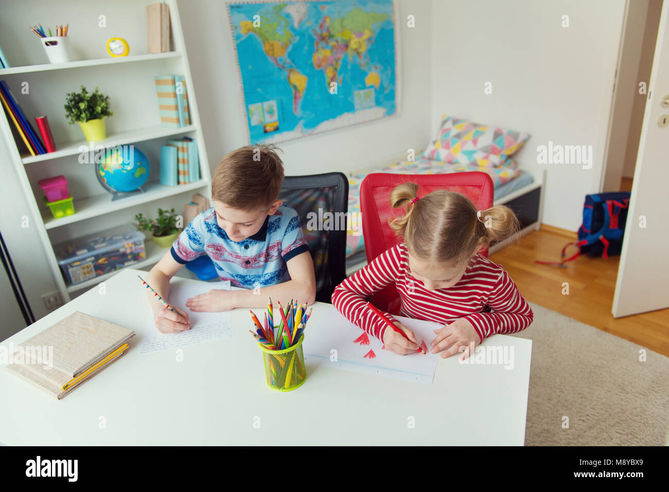 Two cute children drawing with colorful pencils at home Stock Photo - Alamy