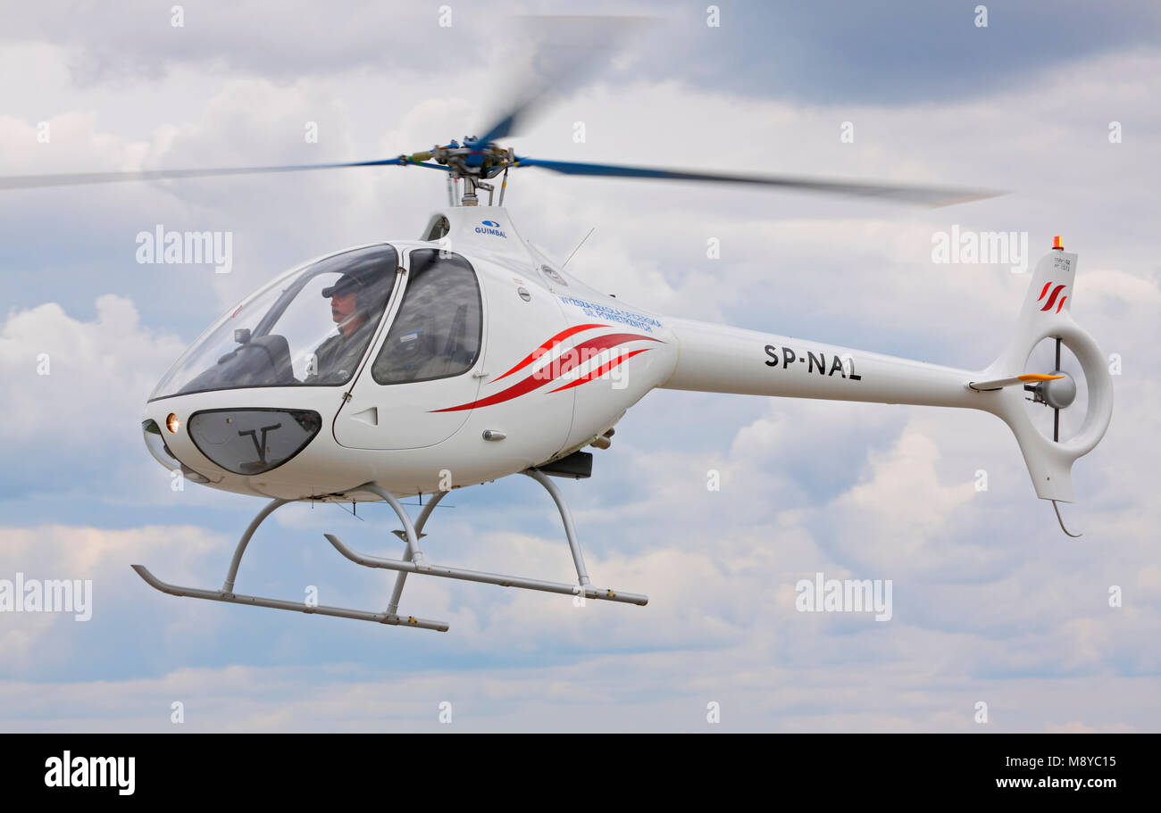 Light helicopter Guimbal Cabri G2 flying over cloudy sky during ...
