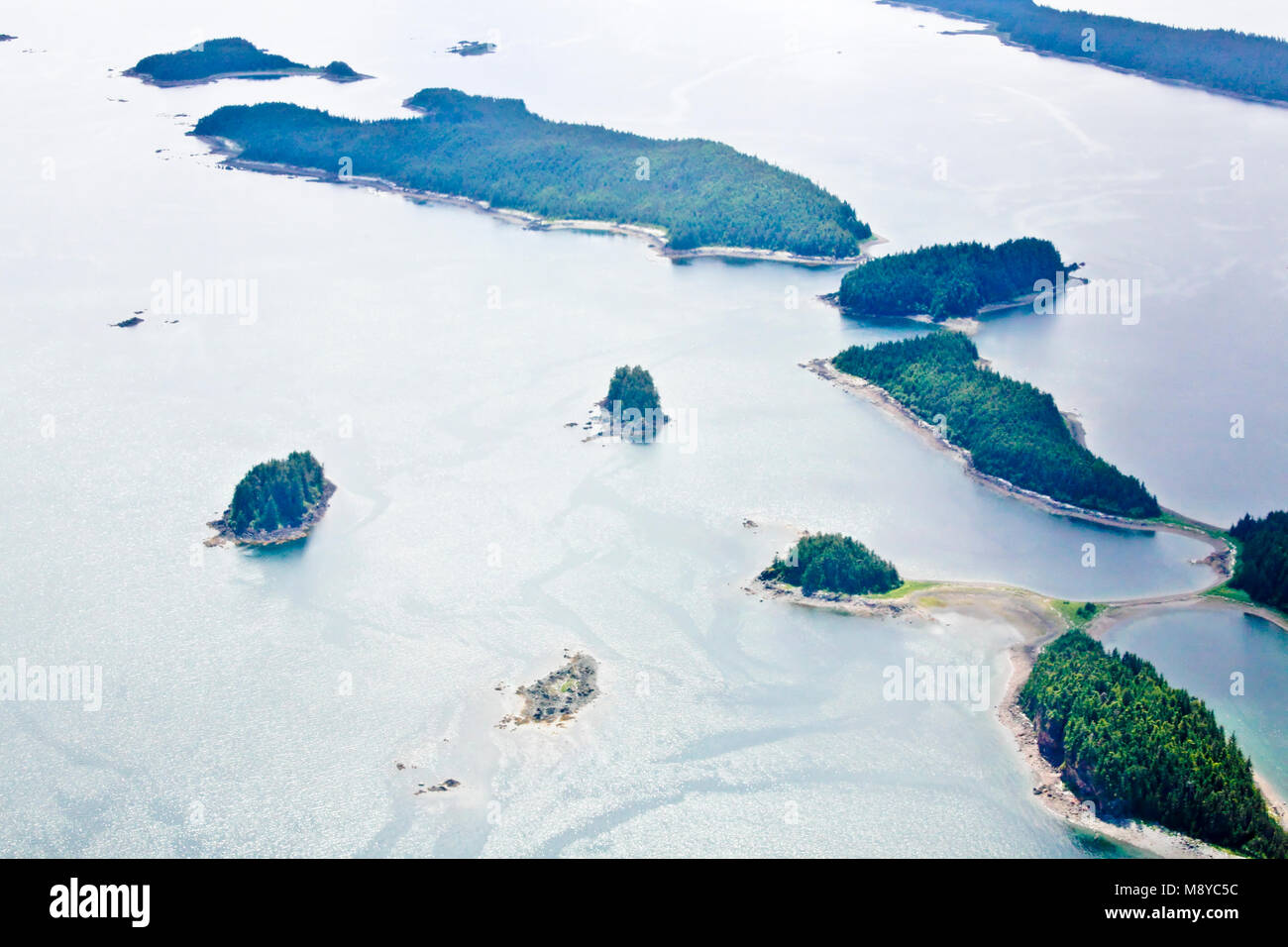 Aerial view of uninhabited areas of Alaska's forested coastline and ...