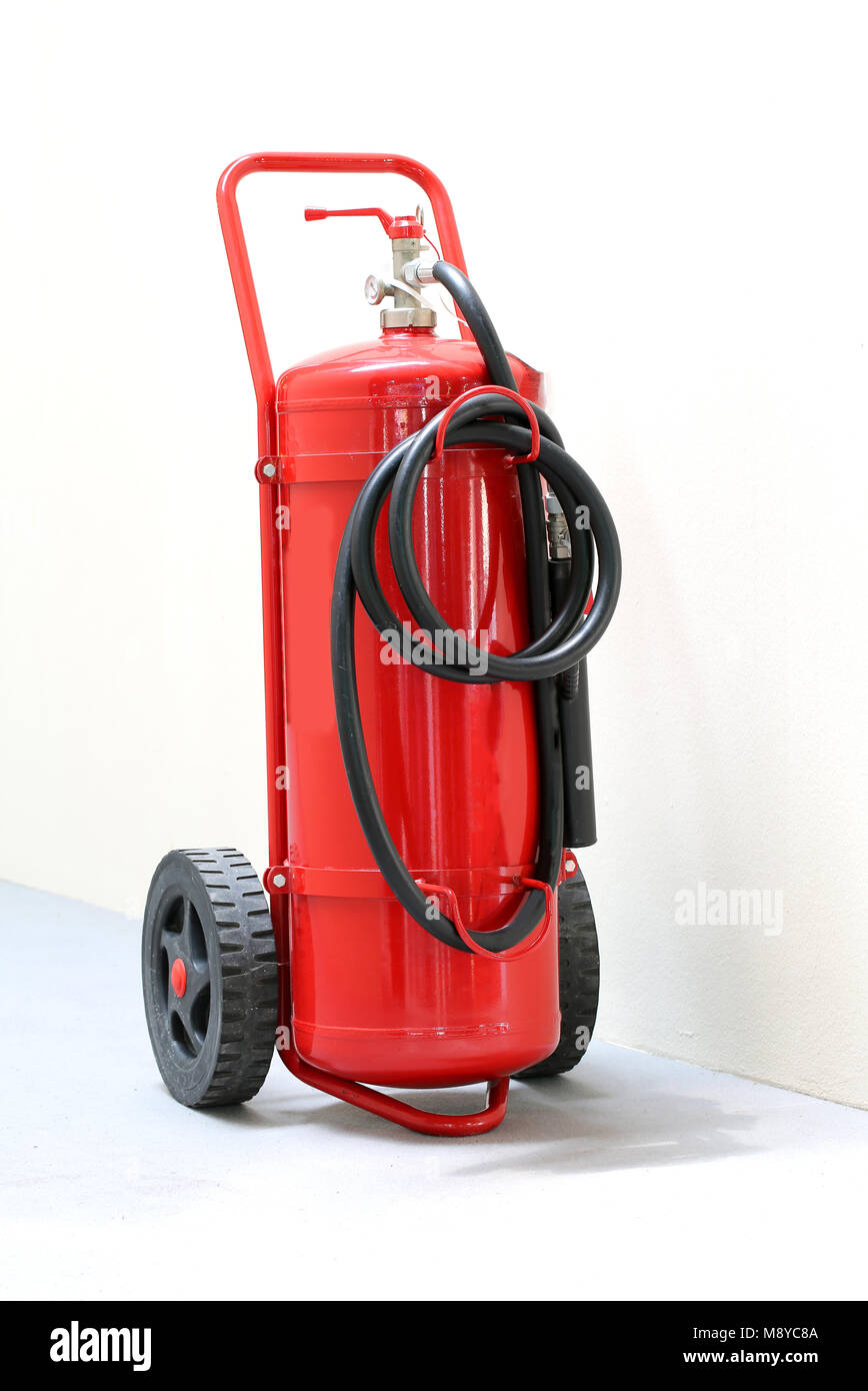 Big wheeled fire extinguisher with black pipe Stock Photo - Alamy