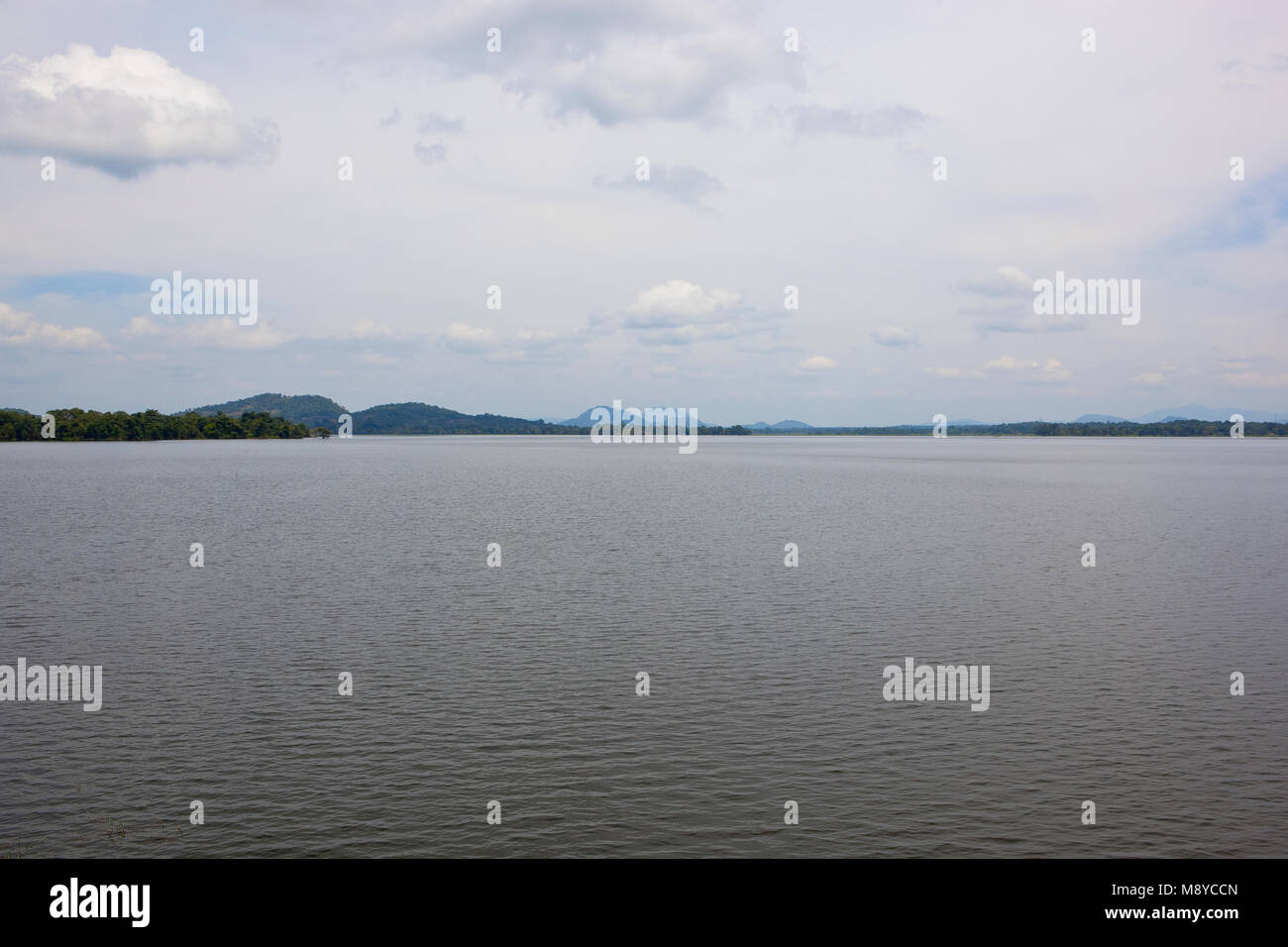 scenic sri lankan sorabora lake with wooded hills and rippled water ...