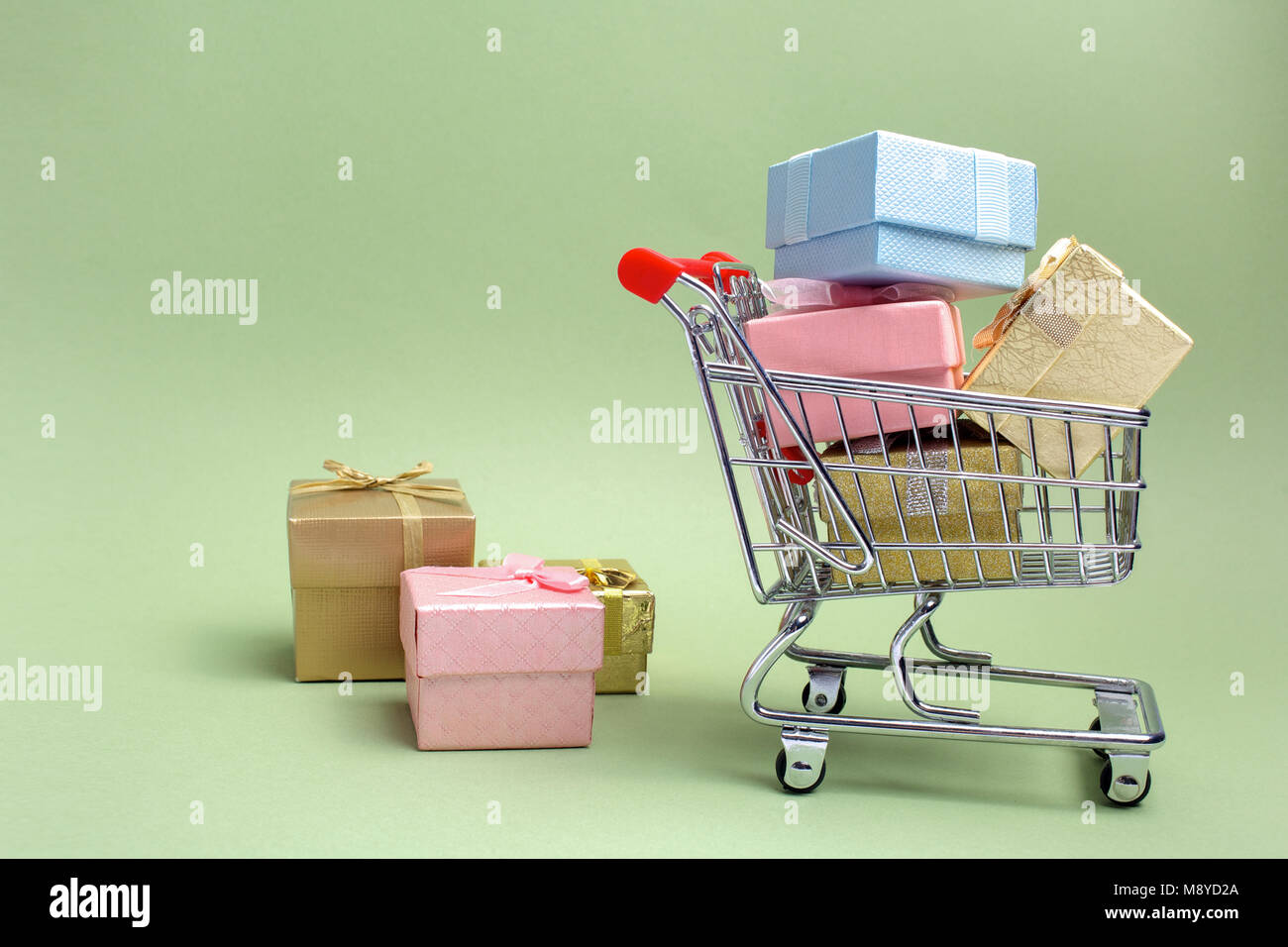Colorful gifts box, supermarket shopping cart on green background with ...