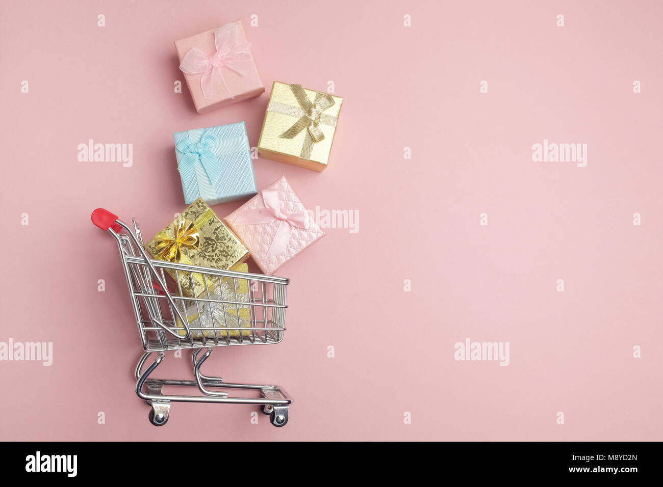 Colorful gifts box, supermarket shopping cart on pink background with ...
