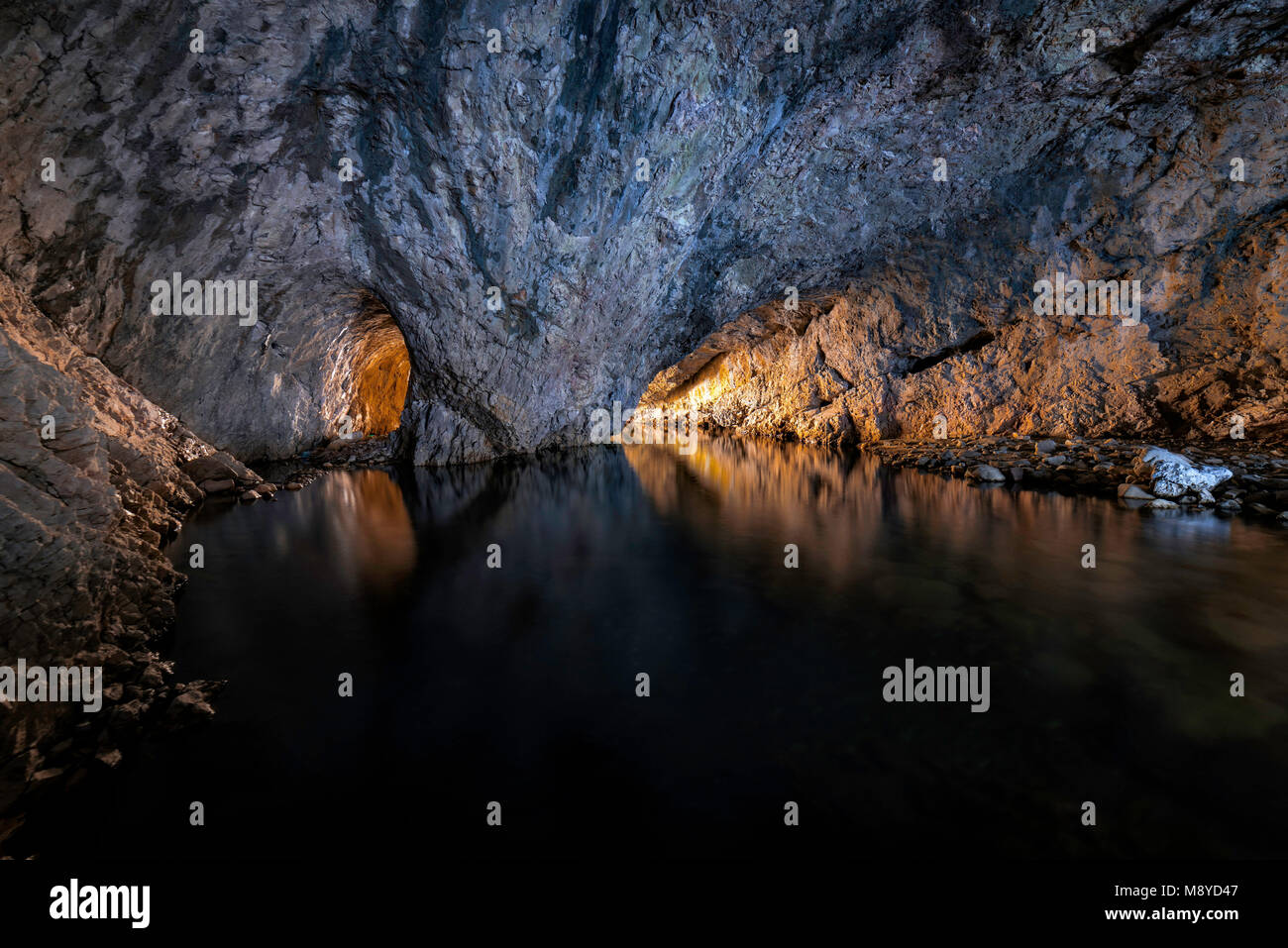 Underground river and cave with outdoor openings show in long exposure ...