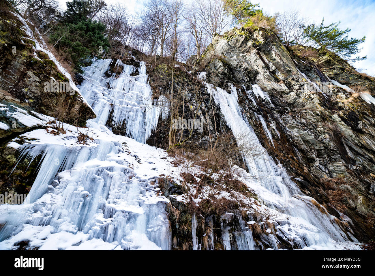 Mountain slopes covered in ice and icicles as the winter snow is ...