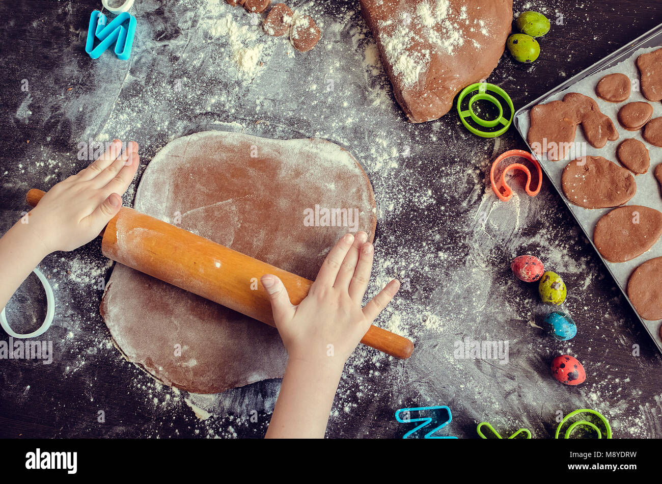 Hands of little girl sheeting dough with rolling pin. Easter baking ...
