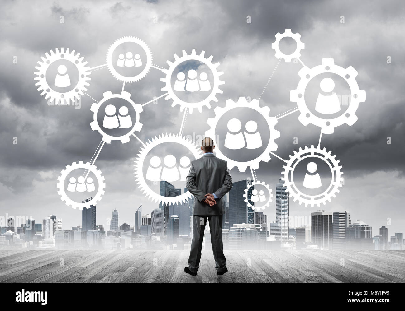 Back view of businessman looking at modern cityscape and gear ...