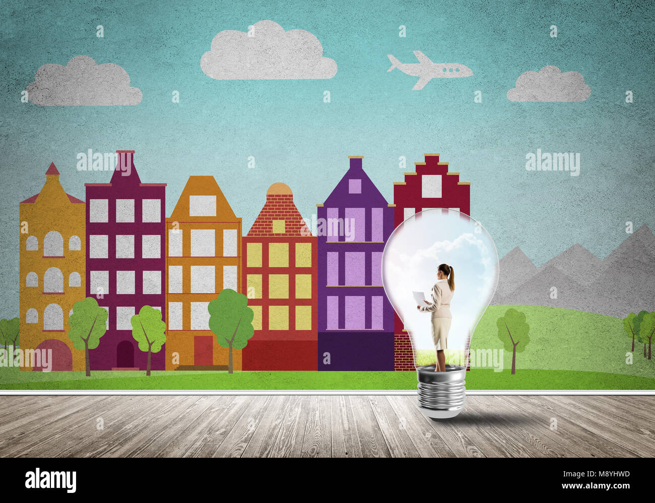 Businesswoman inside light bulb against city drawn concept Stock Photo ...