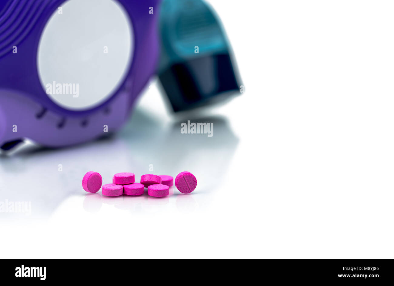 Pile of round pink small tablets pills on blurred background of asthma ...