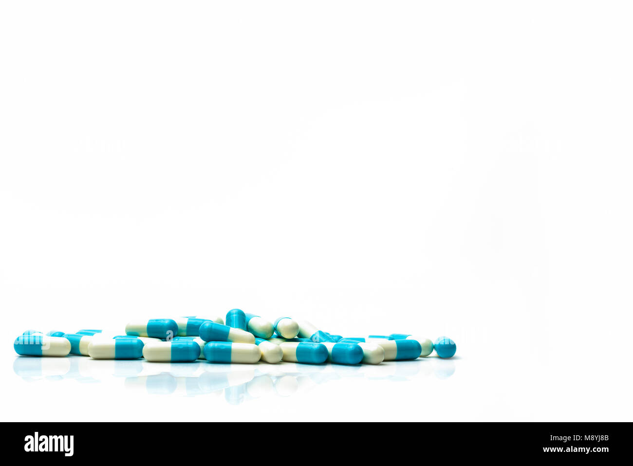 Pile of blue and white capsules pills isolated on white background with ...