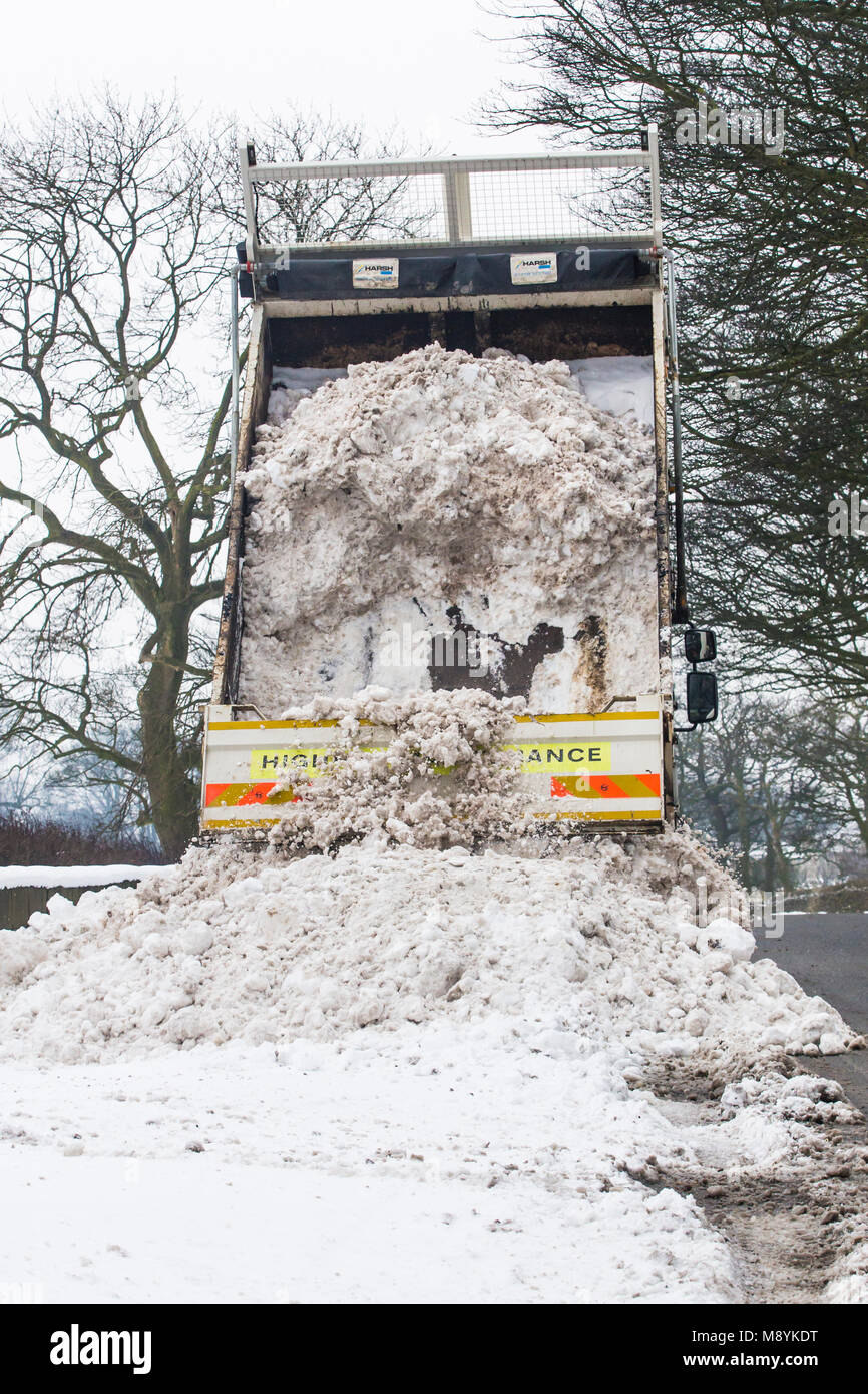 LEEDS, UK – 3 MARCH 2018. Tipper truck emptying load of snow into large ...