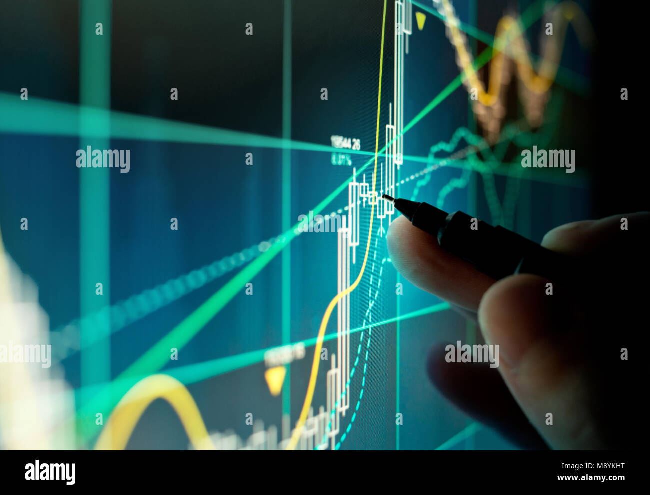 A stock trader checking technical markers of a stock on a computer ...