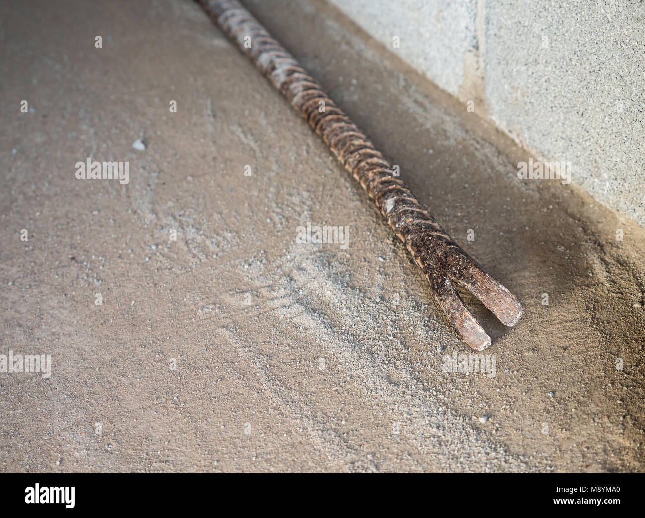 Selective focus of the old crowbar on the concrete floor near the wall ...