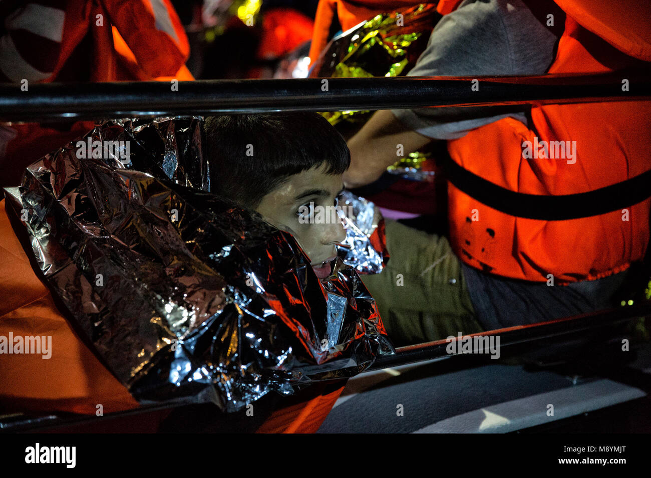 A boy is wrapped in an emergency blanket provided by rescuers as asylum ...