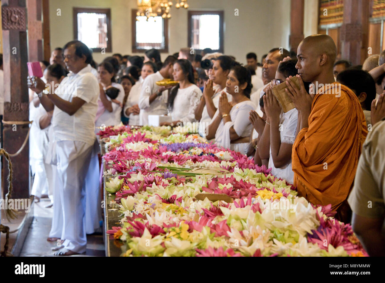 inside the Temple of the tooth relic where people offer flowers and ...