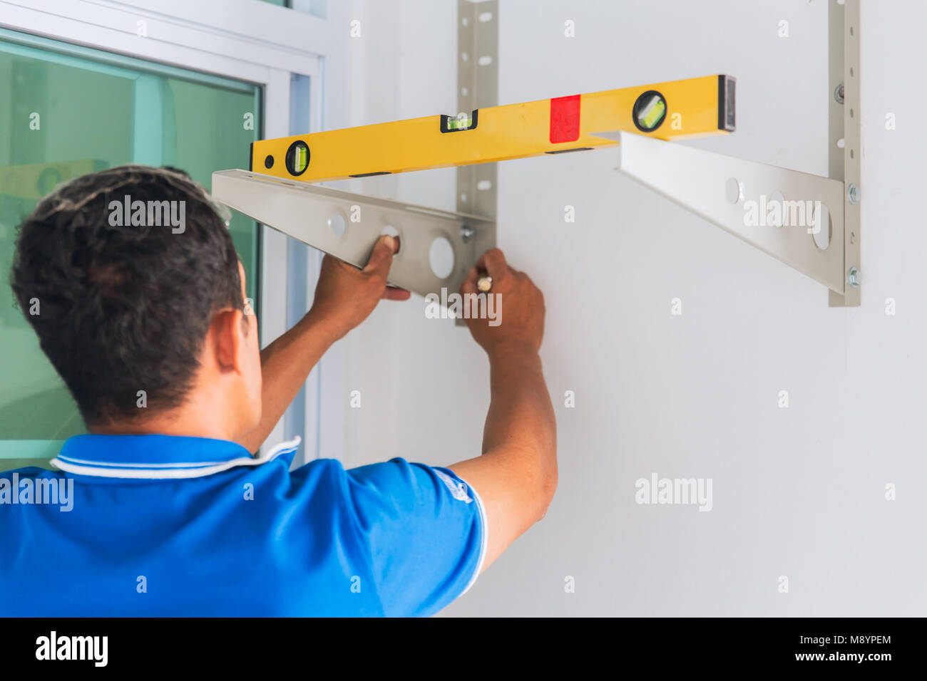 Technicien using Clinometer Bubble Level Ruler tool to install rack for ...