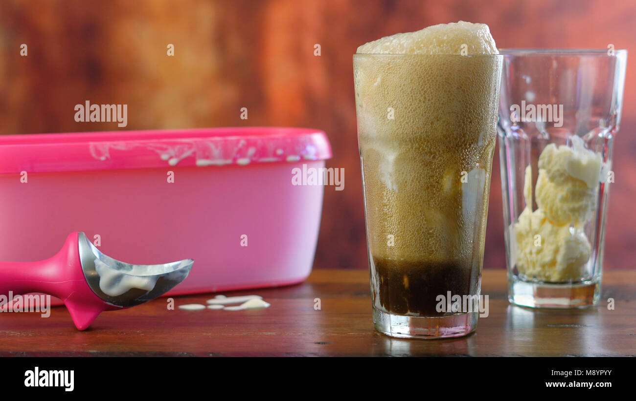 Preparing black cow cola ice cream soda floats against rustic wood ...