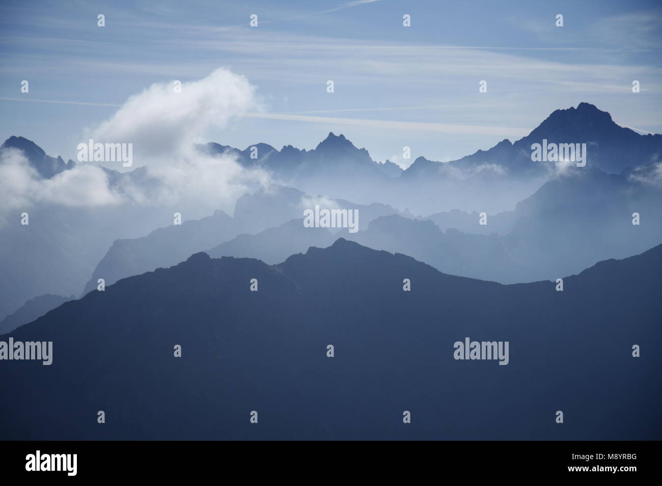 Blue layers of sharp mountain ridges with clouds, Tatra Mountains ...