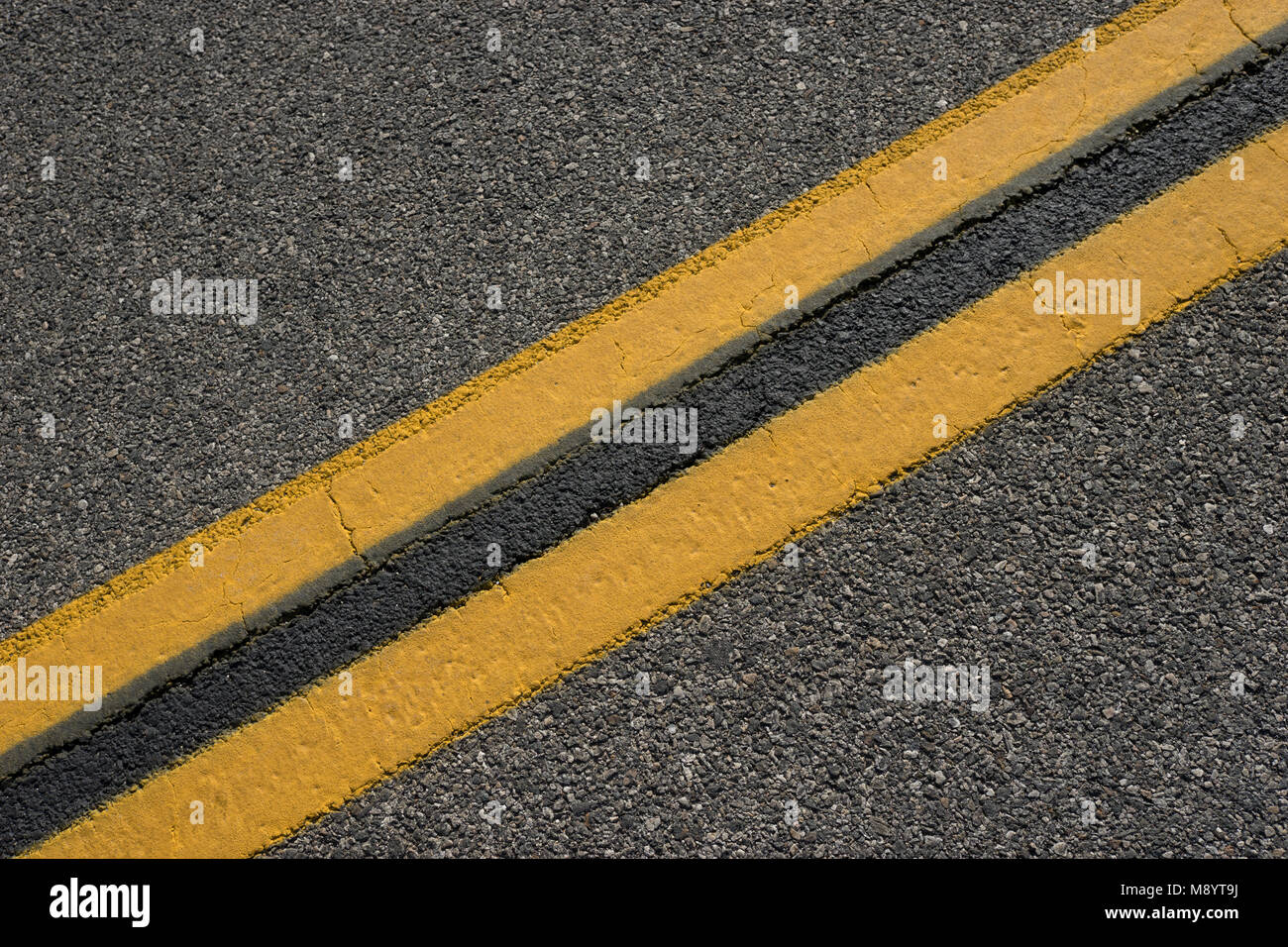 Two yellow lines form a matching pair on an asphalt road Stock Photo ...