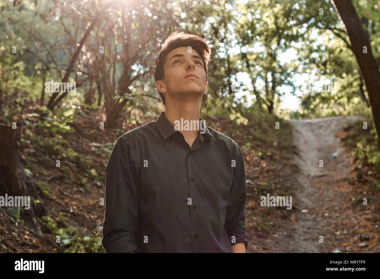 Pensive faithful teenage boy looking up hoping Stock Photo - Alamy