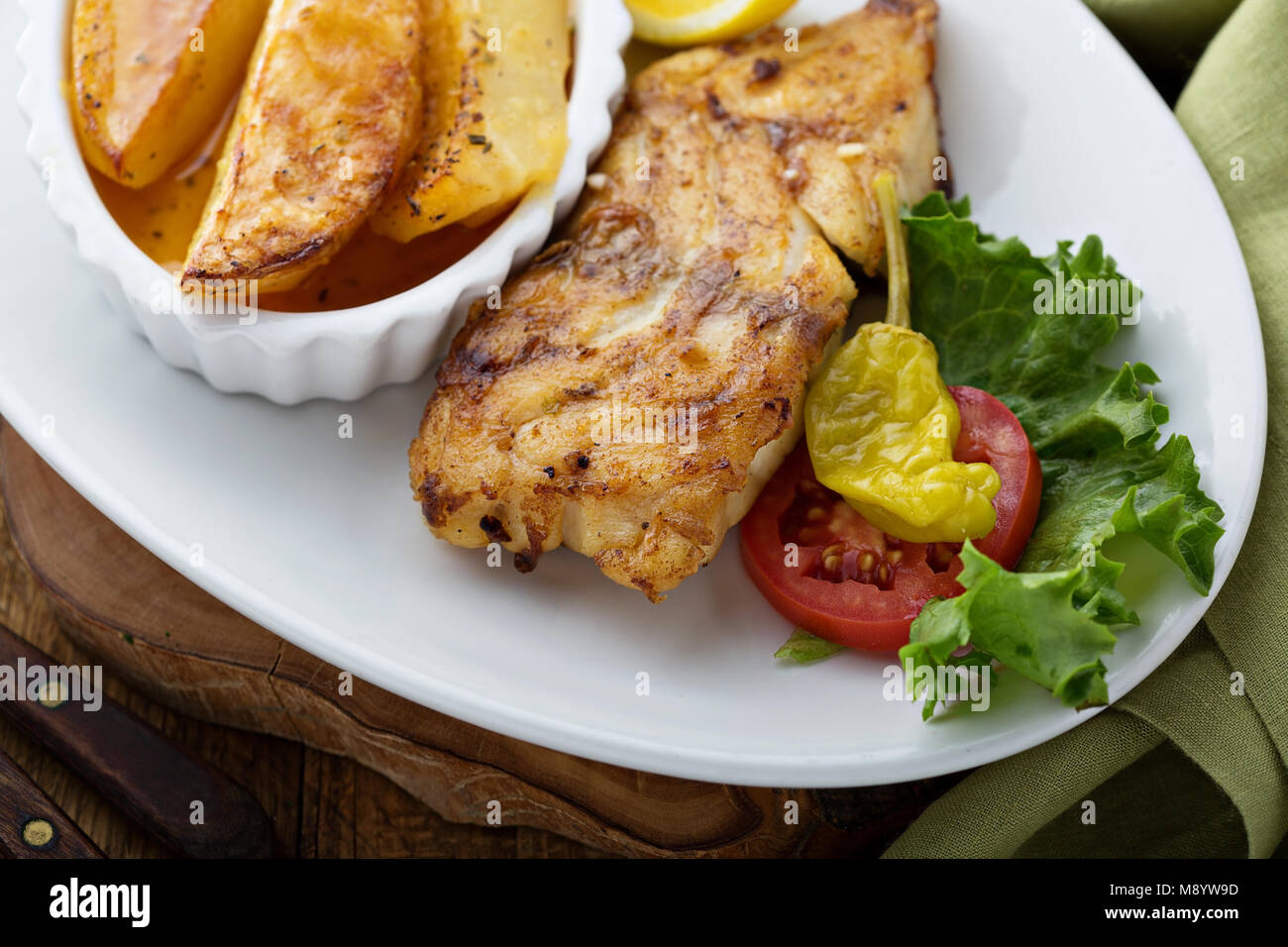 Grilled fish with roasted potatoes Stock Photo - Alamy