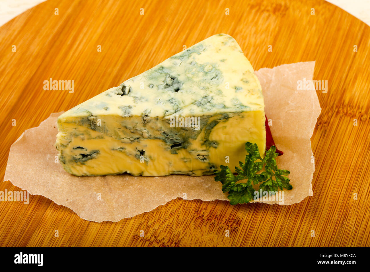 Blue cheese with parsley over wooden background Stock Photo - Alamy