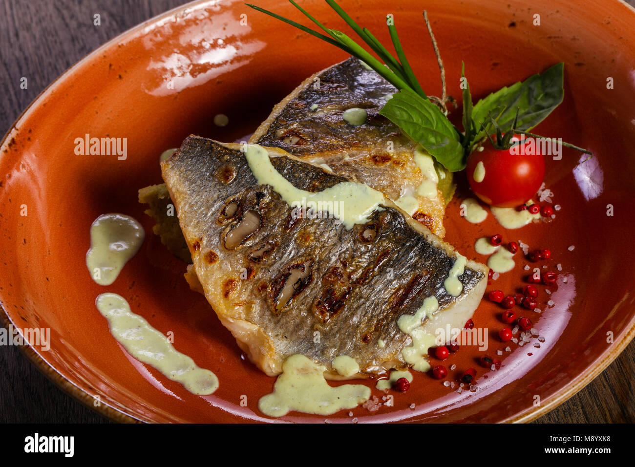 Grilled dorada fillet served tomato and onion Stock Photo - Alamy