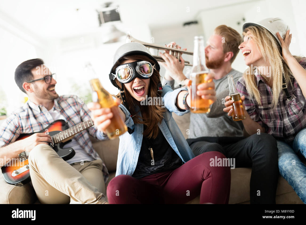 Cheerful friends having party and drinking beer Stock Photo - Alamy