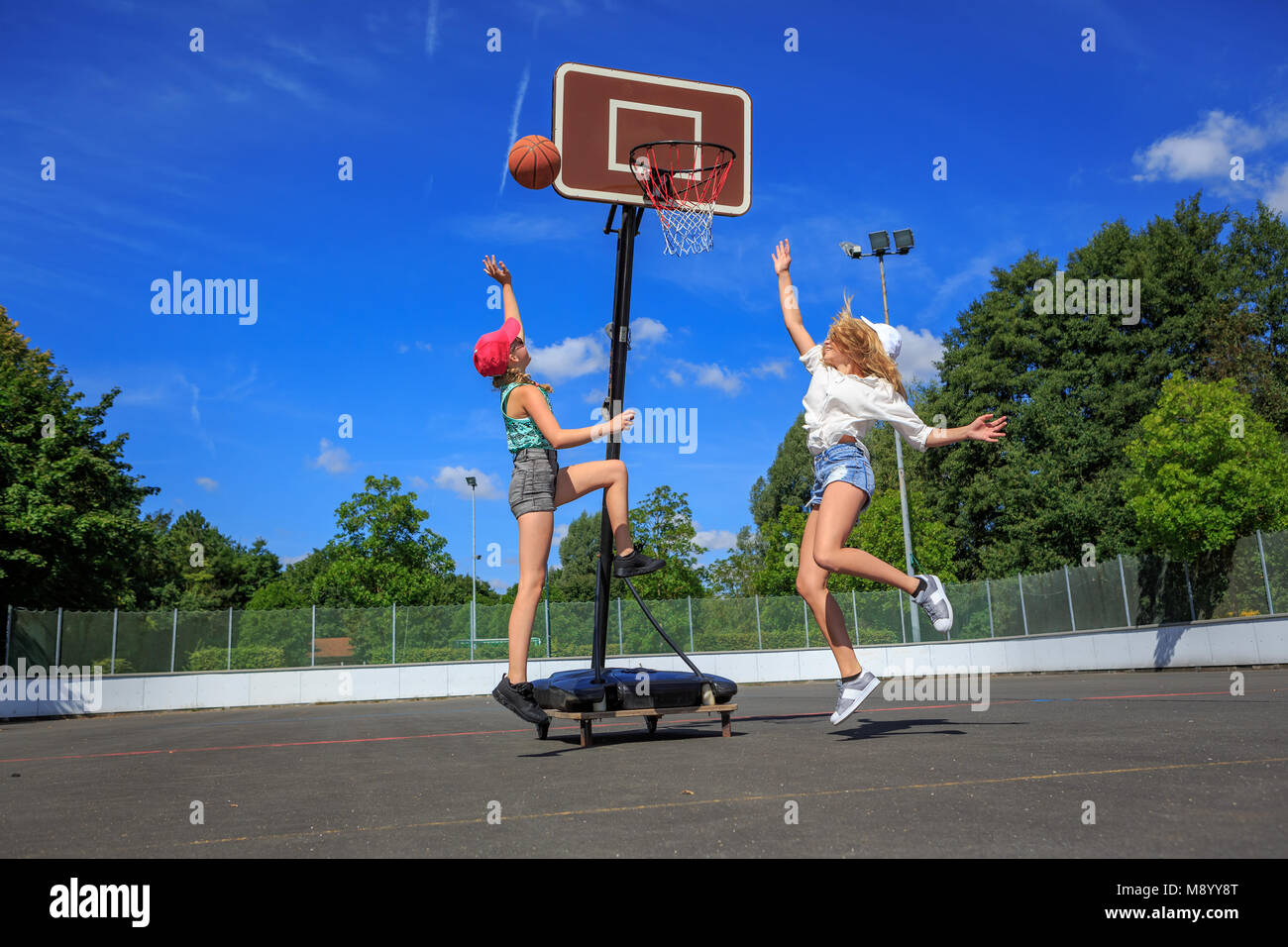 two teenage girls playing basketball in the park Stock Photo - Alamy