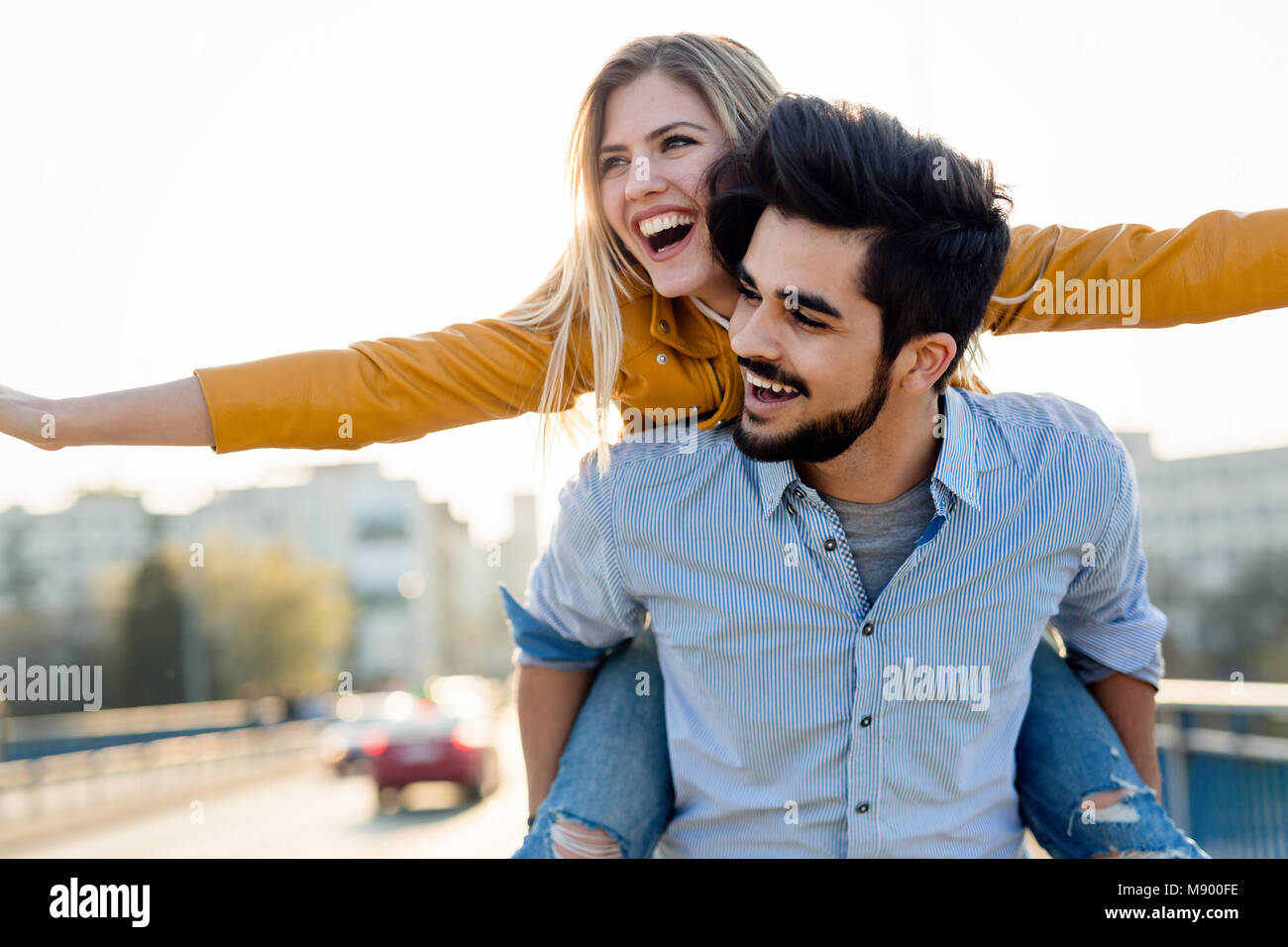 Couple in love cuddling while enjoying beautiful urban sunset together ...