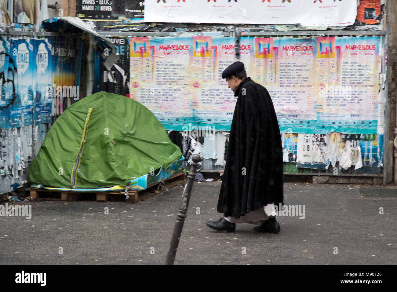 Motion of French priest walking past homeless tent in Paris France ...