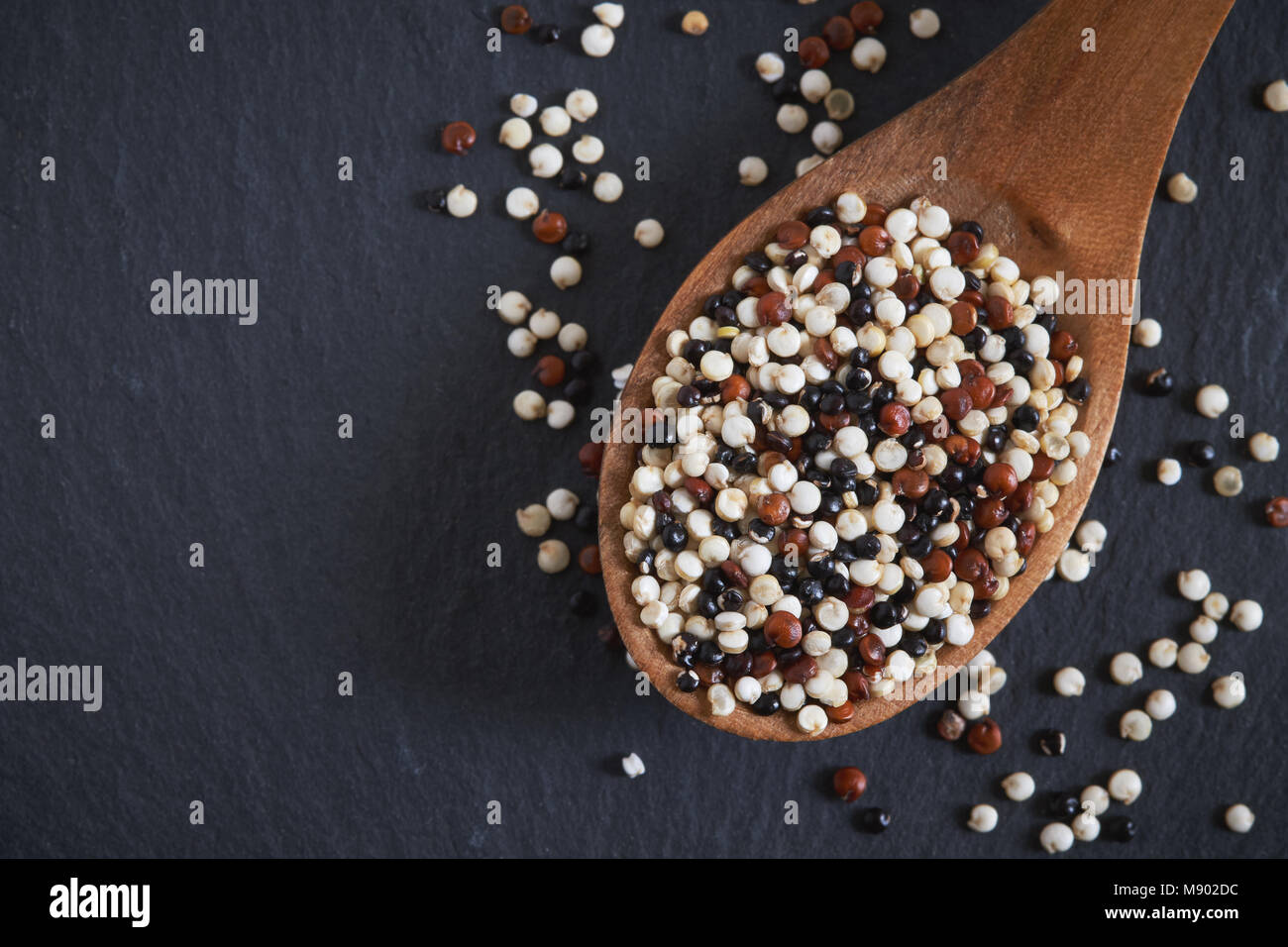 Mixed raw quinoa (Chenopodium quinoa). Red, black and white seeds in ...