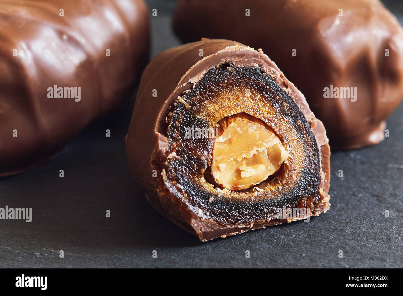Chocolate covered dates stuffed with almonds on black background Stock ...