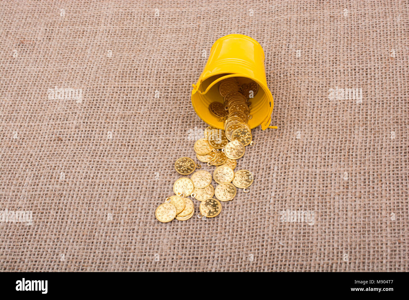 Bucket and plenty of fake gold coins on canvas Stock Photo - Alamy