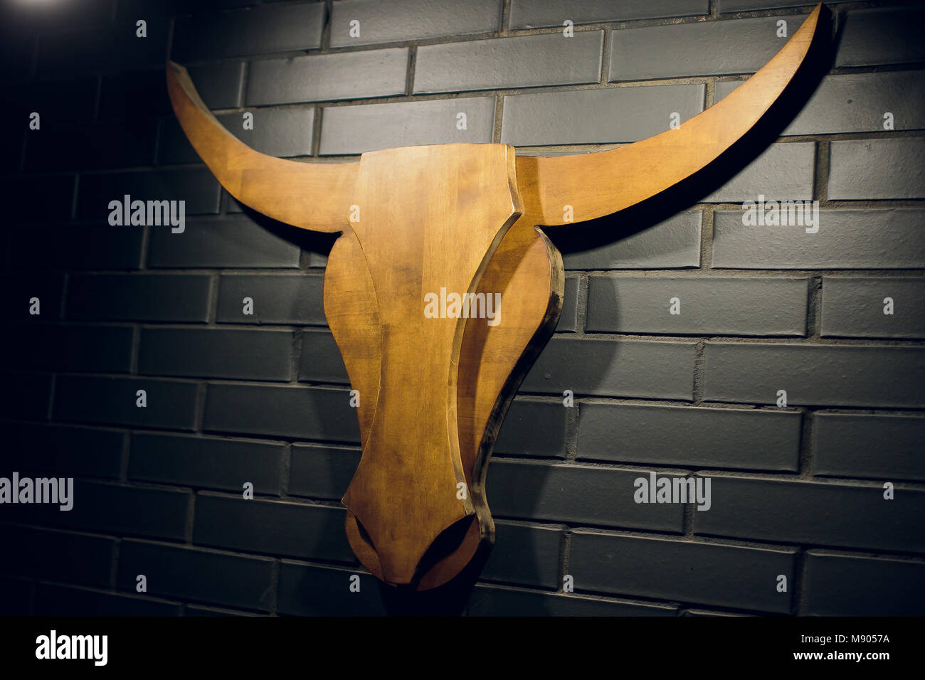 Bull head carved with old wood. Backround bricks Loft Stock Photo - Alamy
