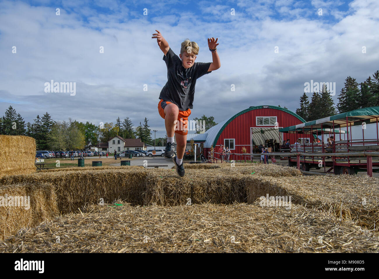 Young boy jumping straw bales Stock Photo - Alamy