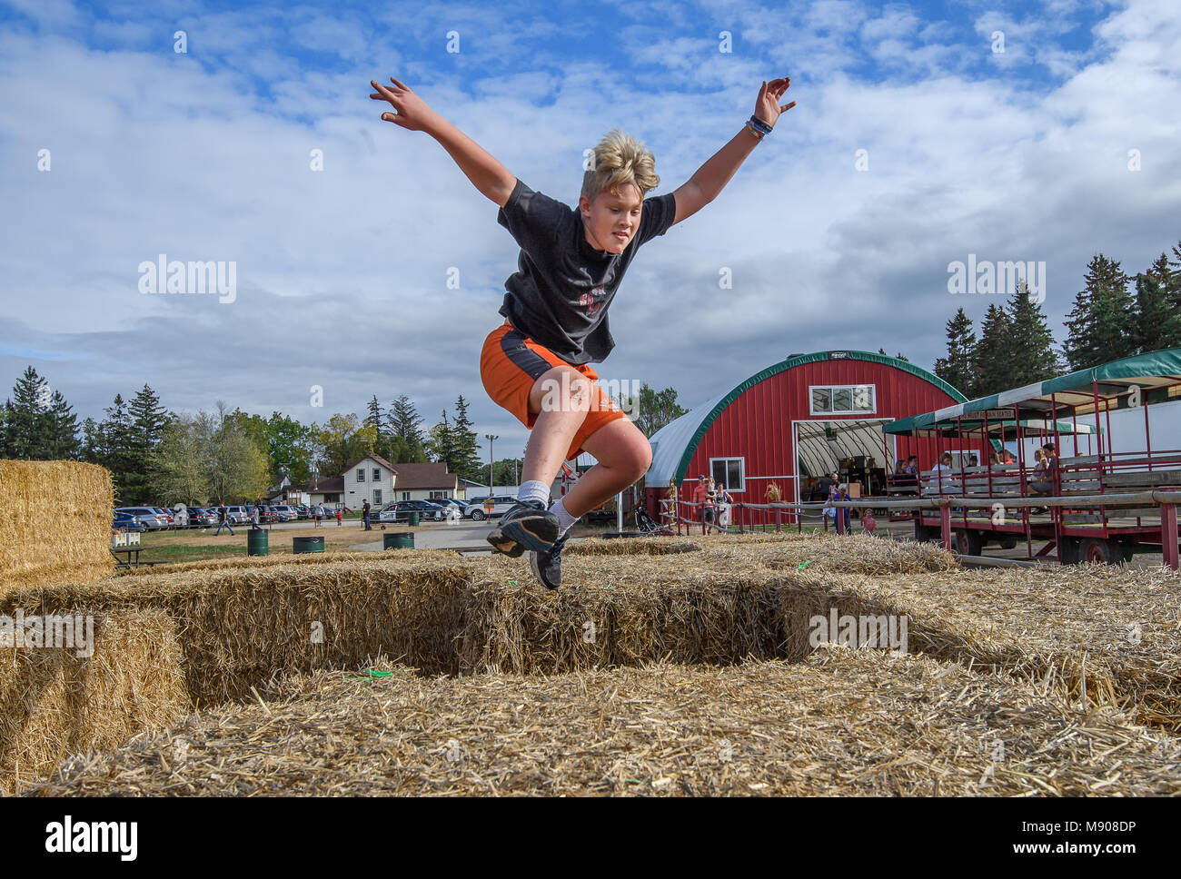 Young boy jumping straw bales Stock Photo - Alamy